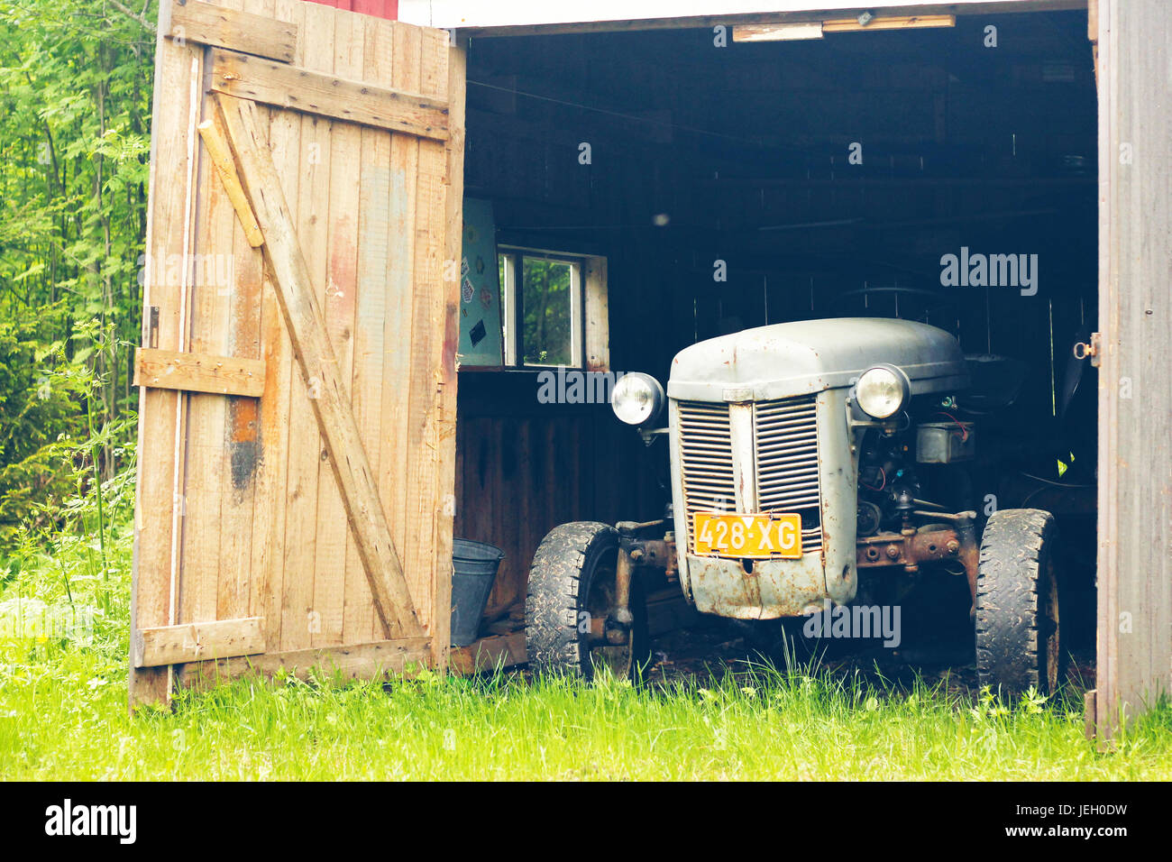 Old grey tractor in a old rustic barn with green background Stock Photo ...