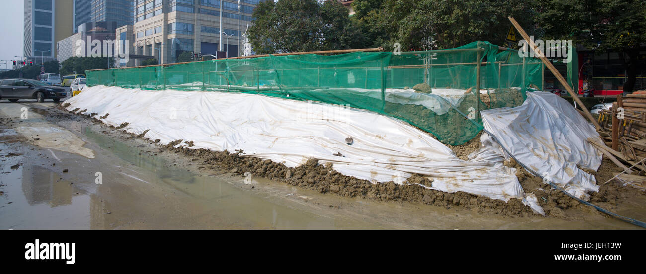 Temporary earth walled and plastic-lined dam on road surface during ...