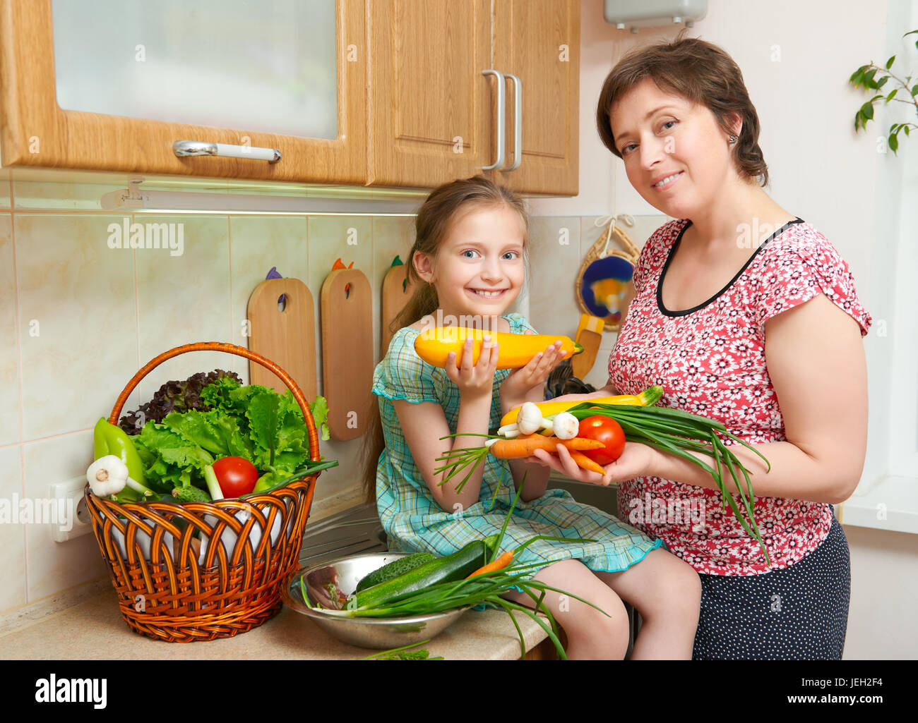 Mother and daughter with basket of vegetables and fresh fruits in ...
