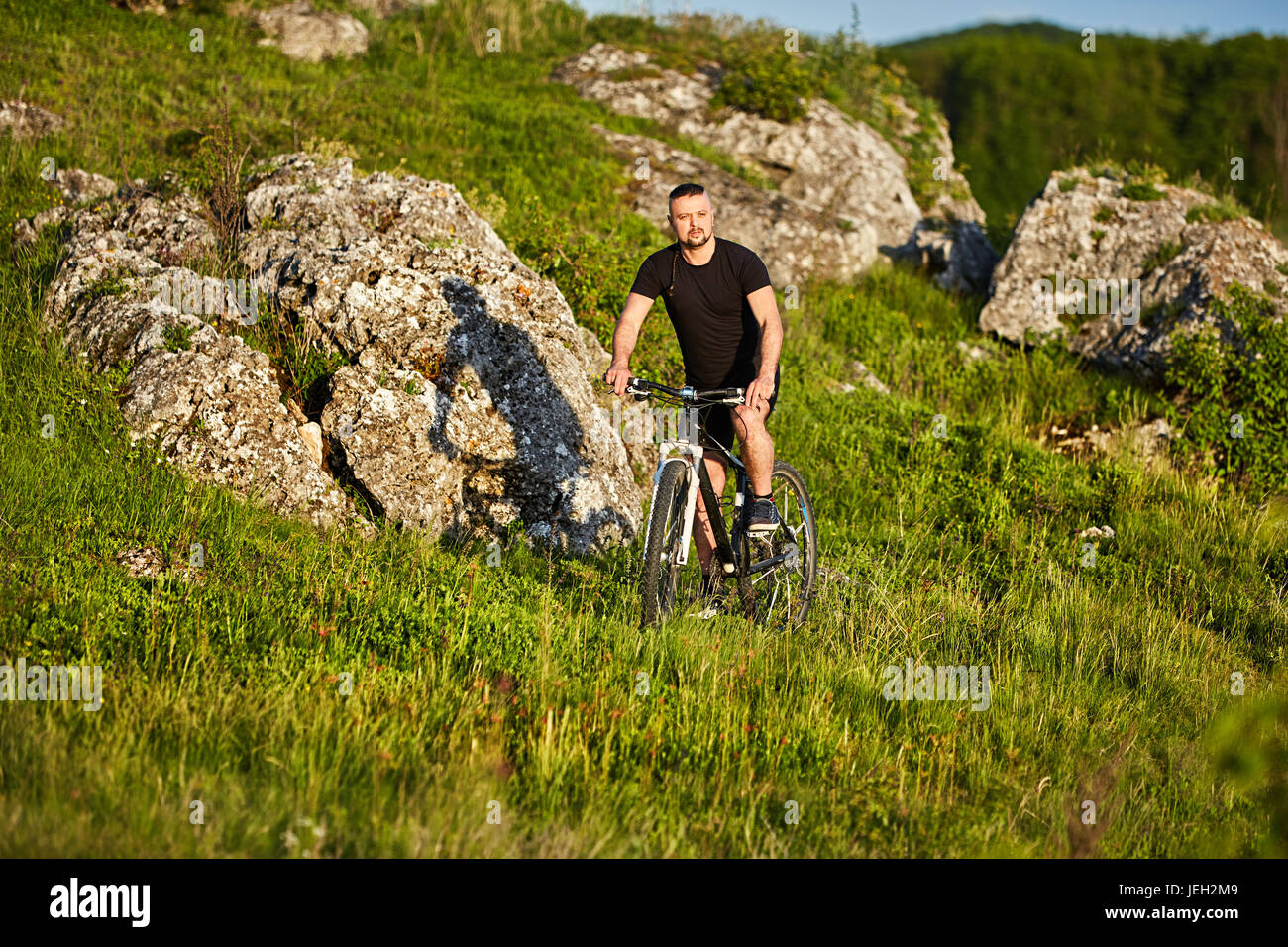 Attractive cyclist riding the bike on summer trail near beautiful big ...