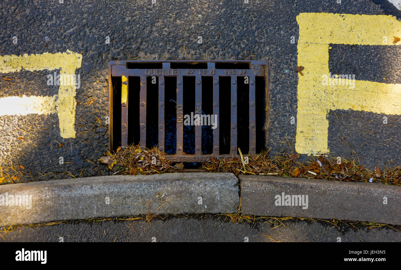 Cast iron drain gate by edge of road kerb Stock Photo - Alamy