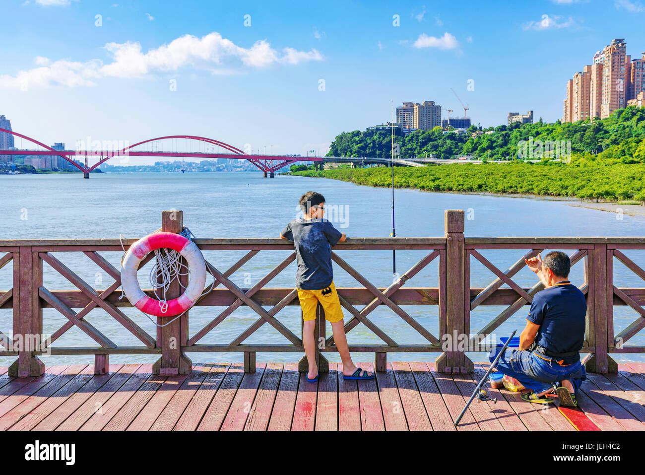 TAIPEI, TAIWAN - MAY 29: Fisherman and his son fishing in the river in ...