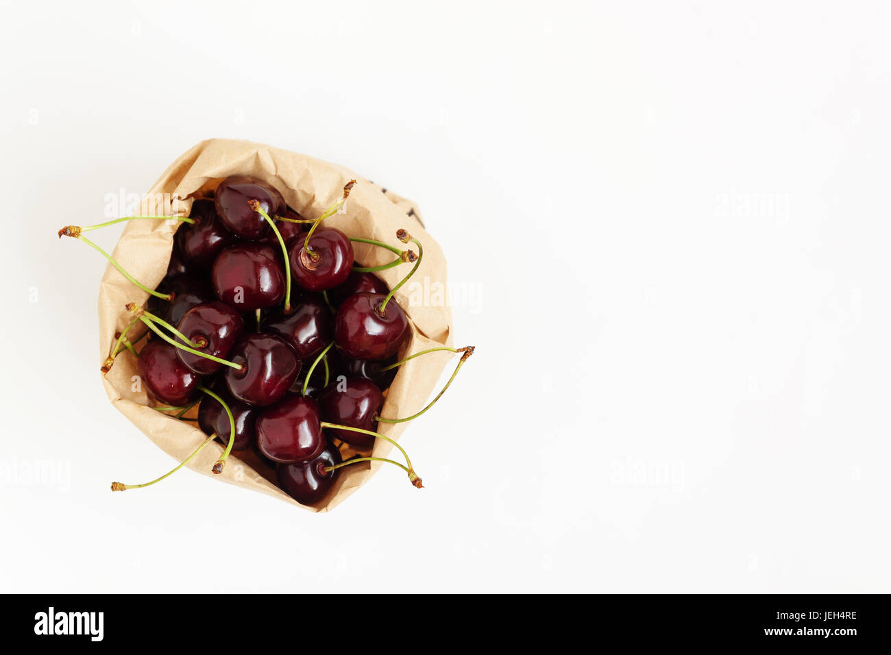 Fresh cherry berries in a paper bag, isolated on a white background ...
