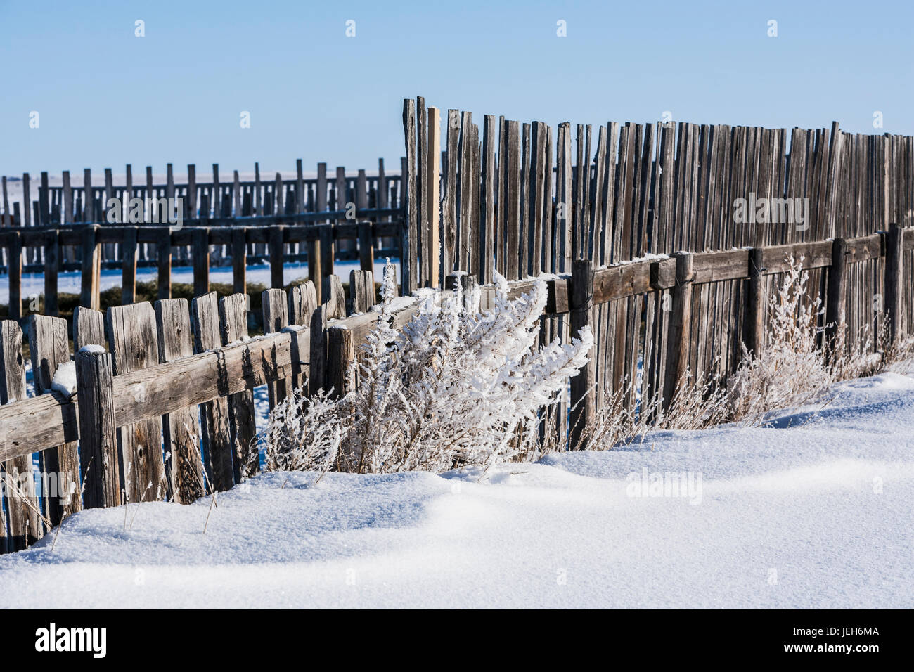 Wooden fences in the snow with blue sky; Alberta, Canada Stock Photo ...