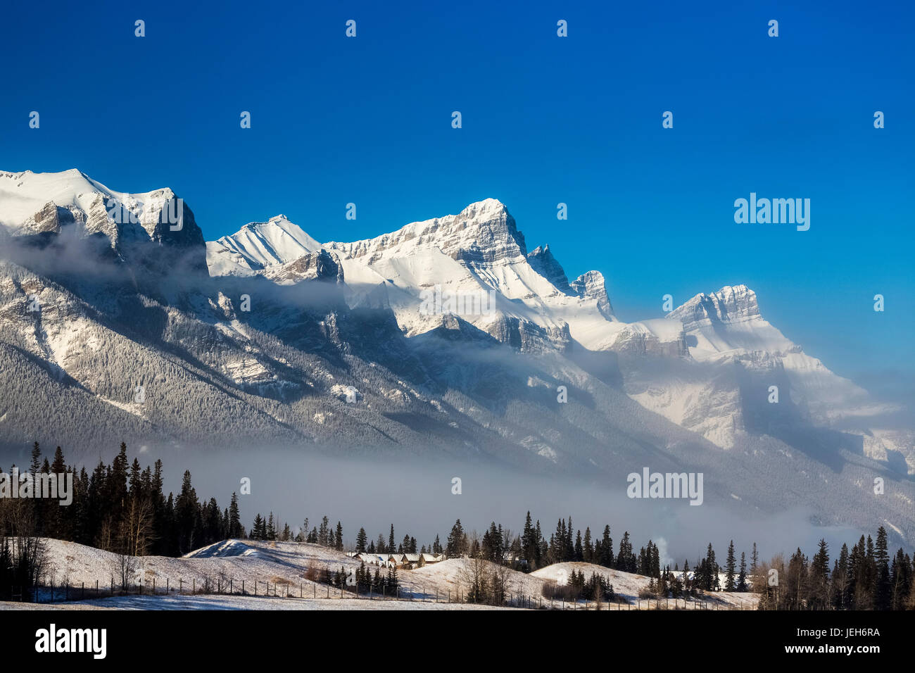 Snow covered mountain range with clouds in the valley, frosted trees ...
