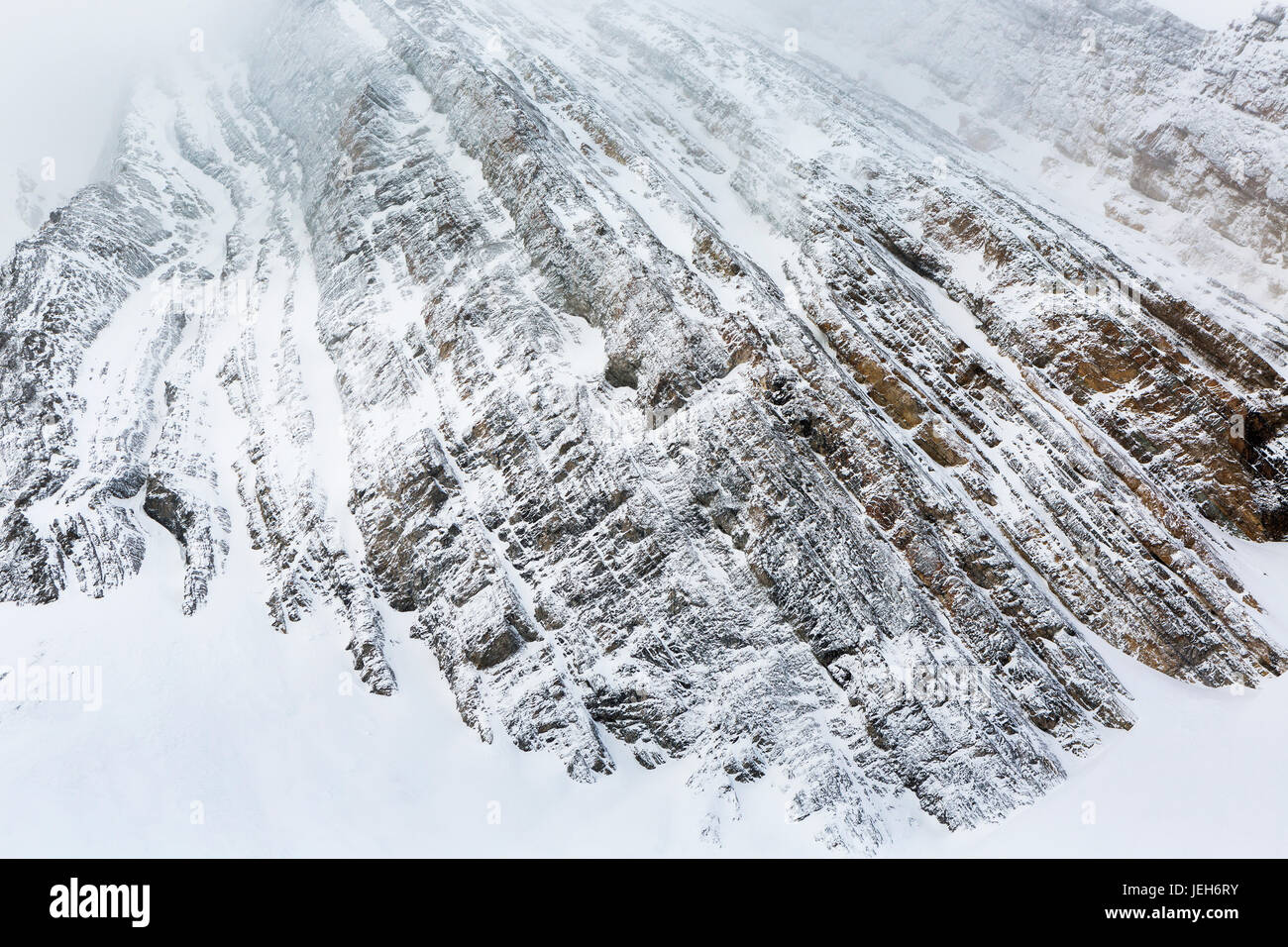 Close up of a snow covered mountain face with line pattern from rock ...