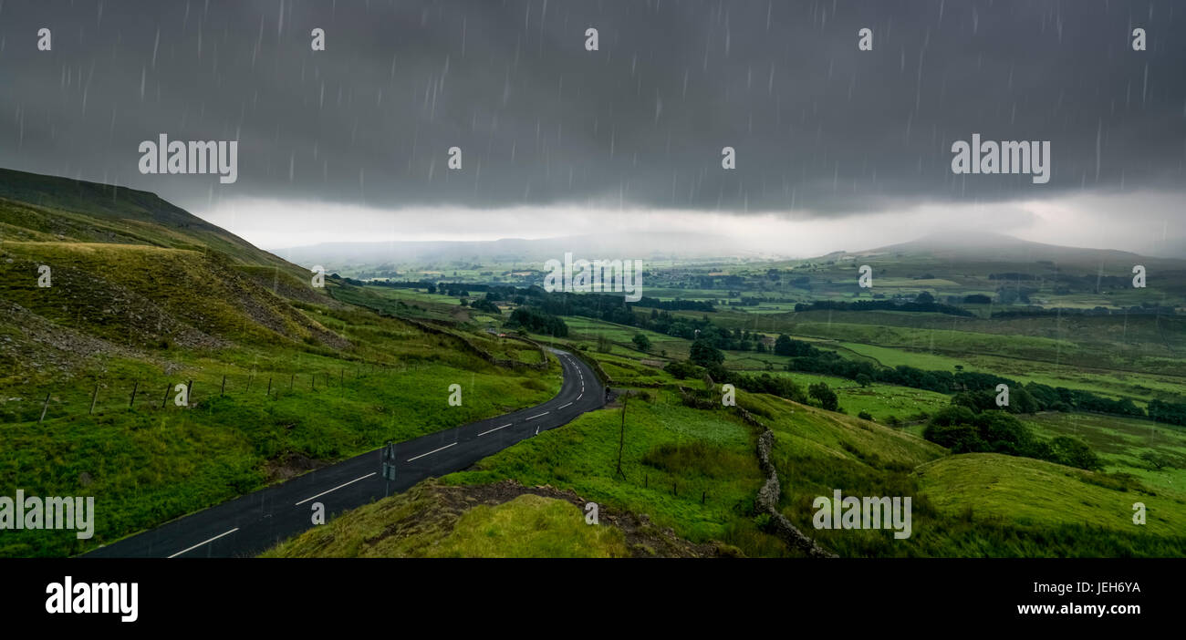 Rain falling from a stormy sky over a lush, green landscape; North ...