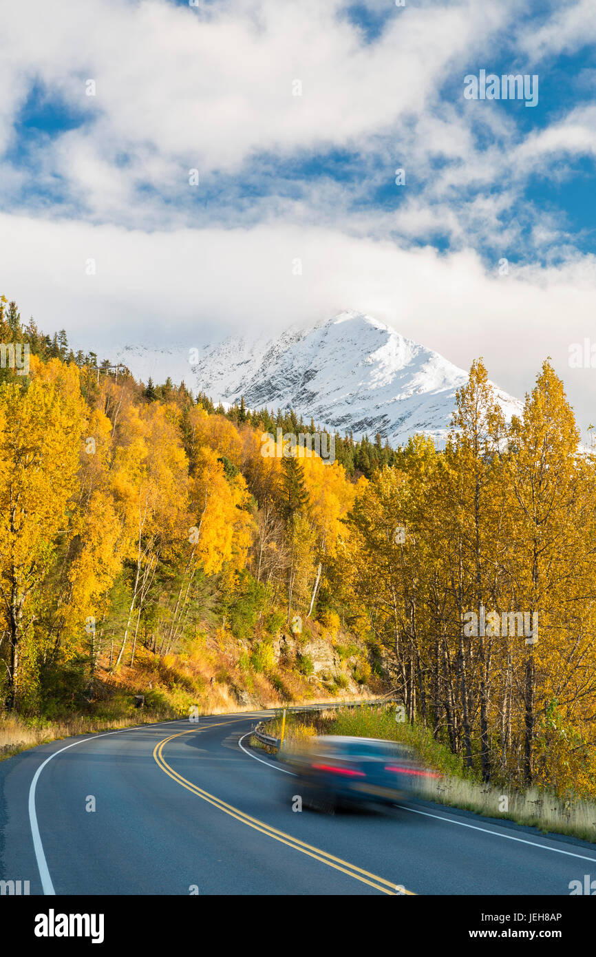 Snow-capped Kenai Mountains dwarf the Seward highway, trees covered in ...