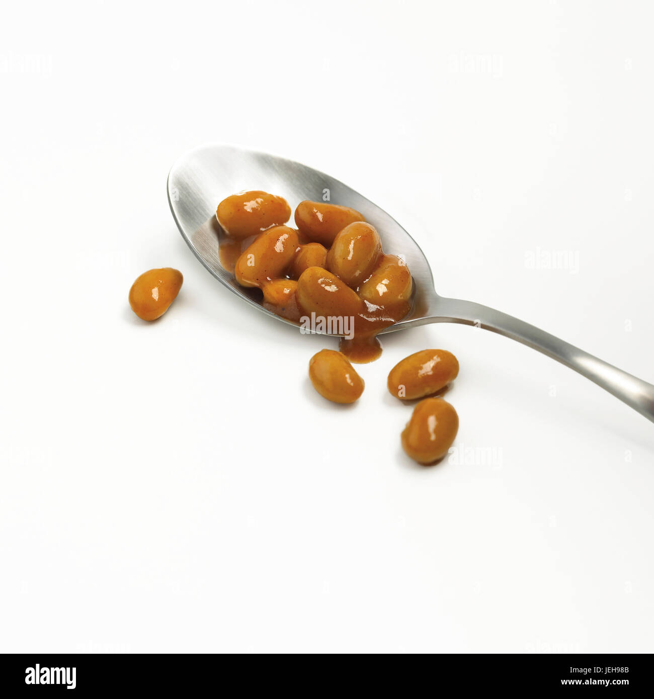 Baked beans on a spoon against a white background Stock Photo - Alamy