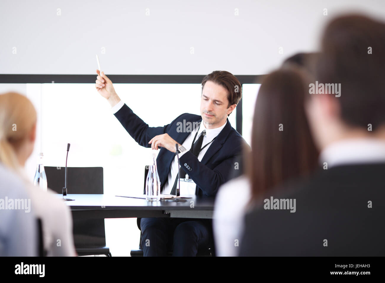 Group of speakers at business meeting at the table with microphones ...