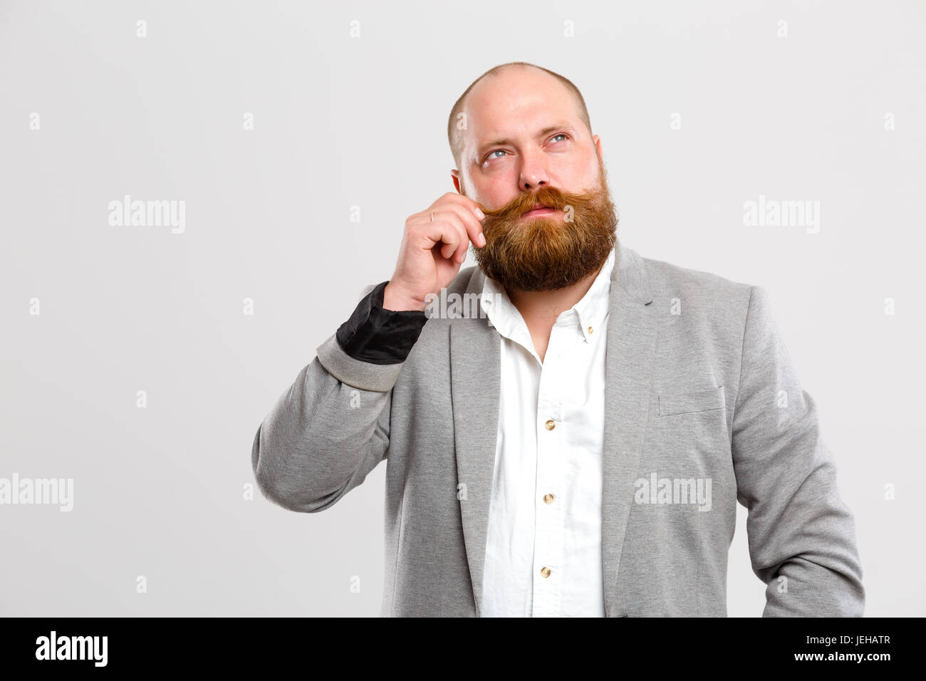 Thoughtful man holds his mustache Stock Photo - Alamy