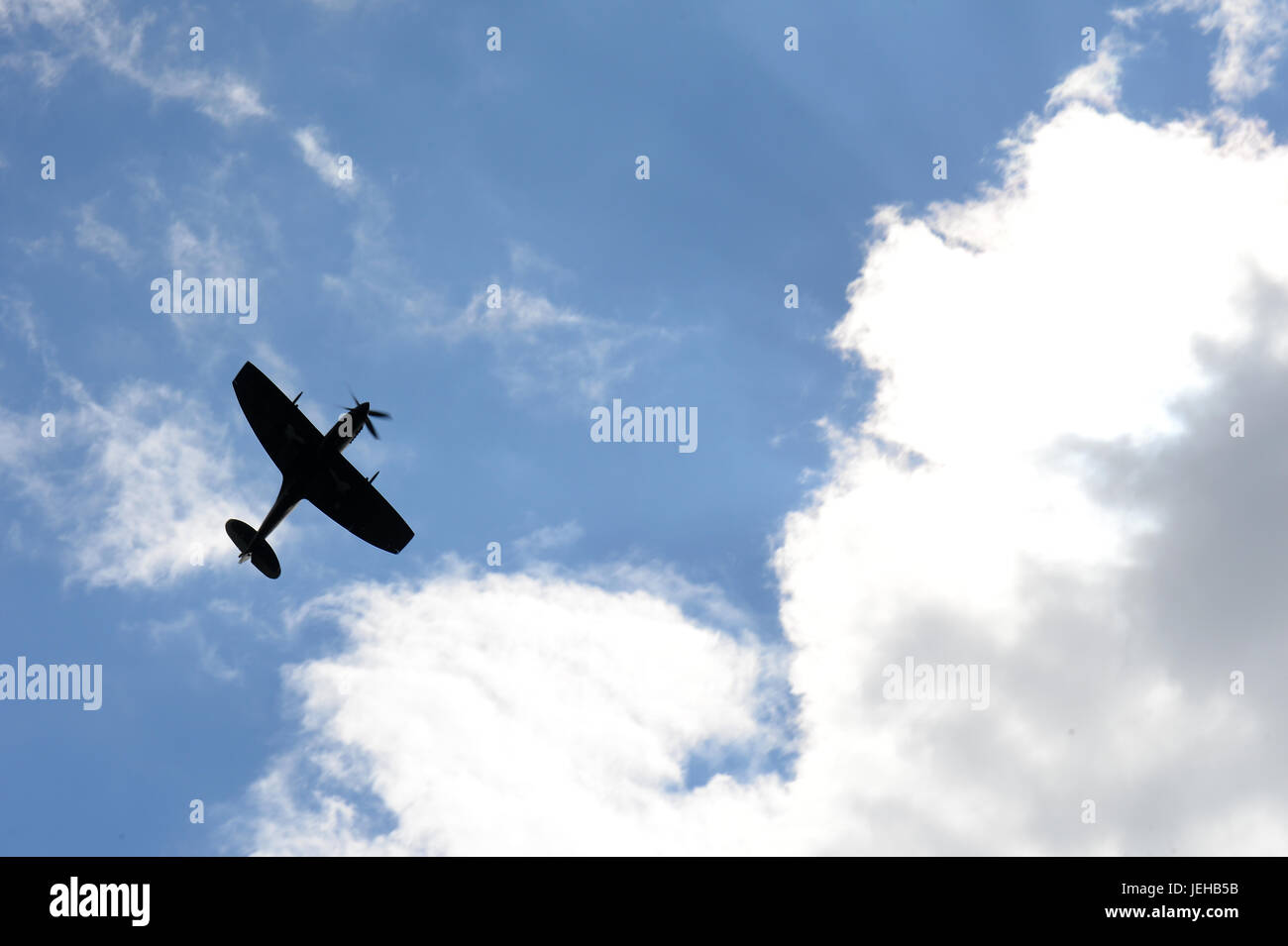 Spitfire in silhouette against blue sky and clouds Stock Photo - Alamy