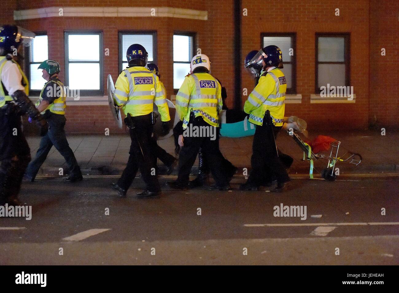 Police officers carry a person on Romford Road in Forest Gate, east ...