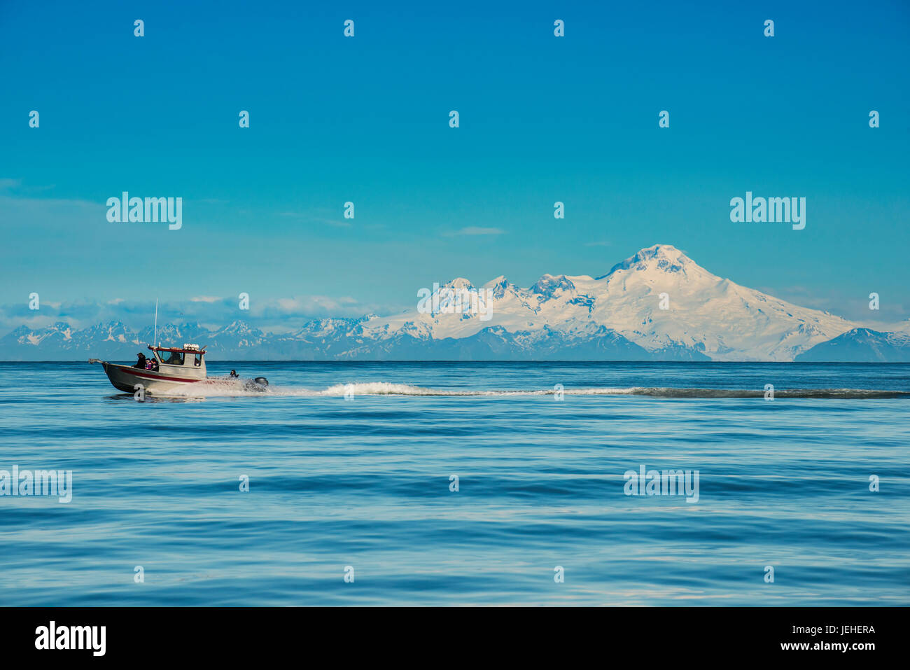 Small boat in Kachemak Bay near Homer, Alaska, with Mt. Iliamna in the ...