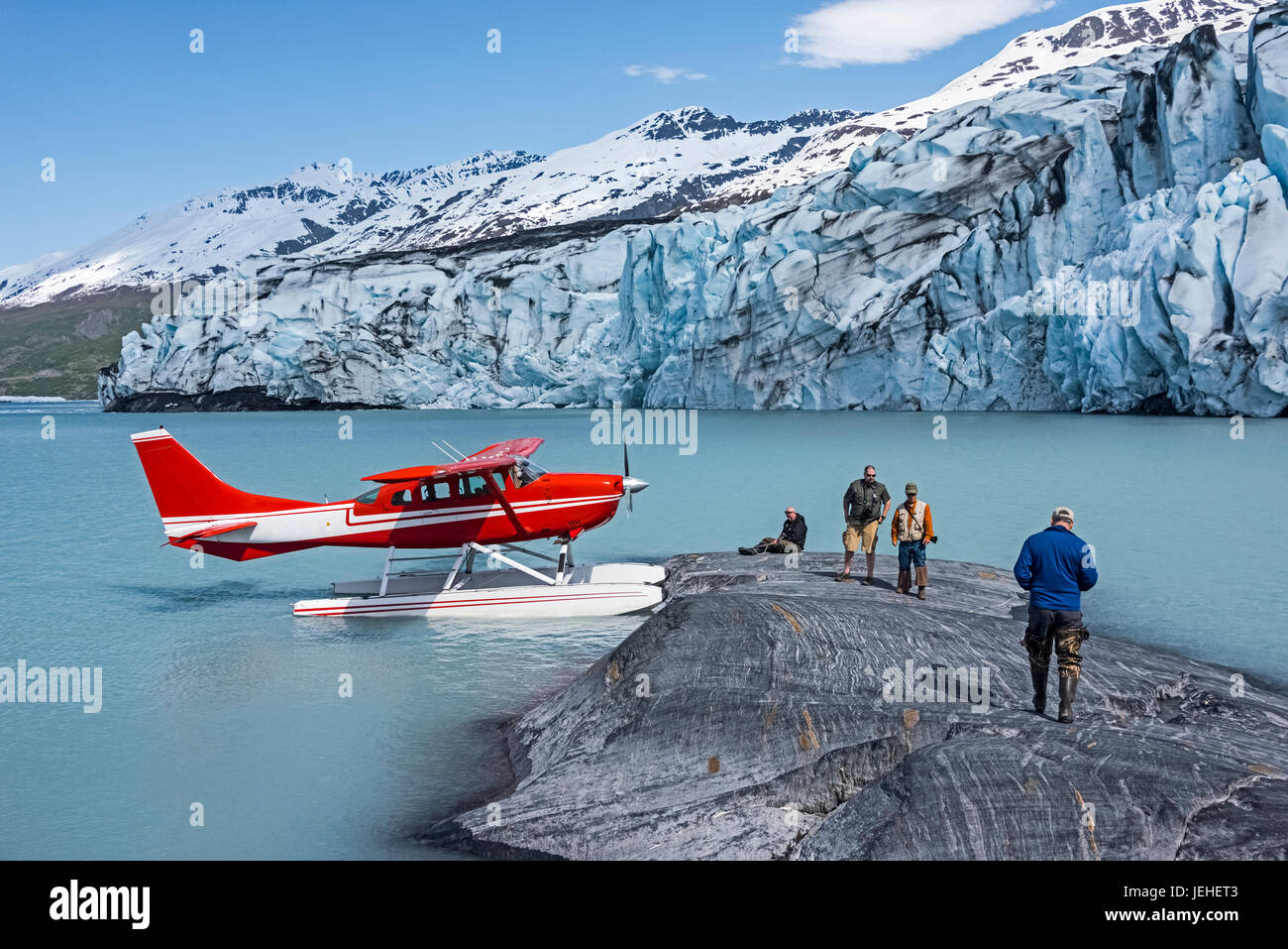 Tourists on a rock outcrop in front of Colony Glacier and Lake George ...