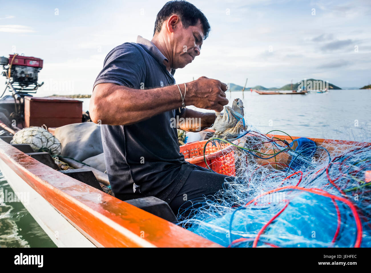 A fisherman working with nets on his fishing boat; Ko Samui, Chang Wat ...