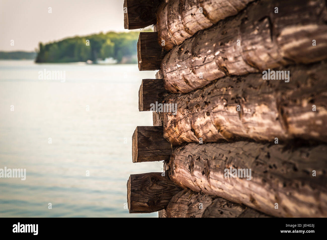 Wall of log house on the river bank close-up with a beautiful landscape ...