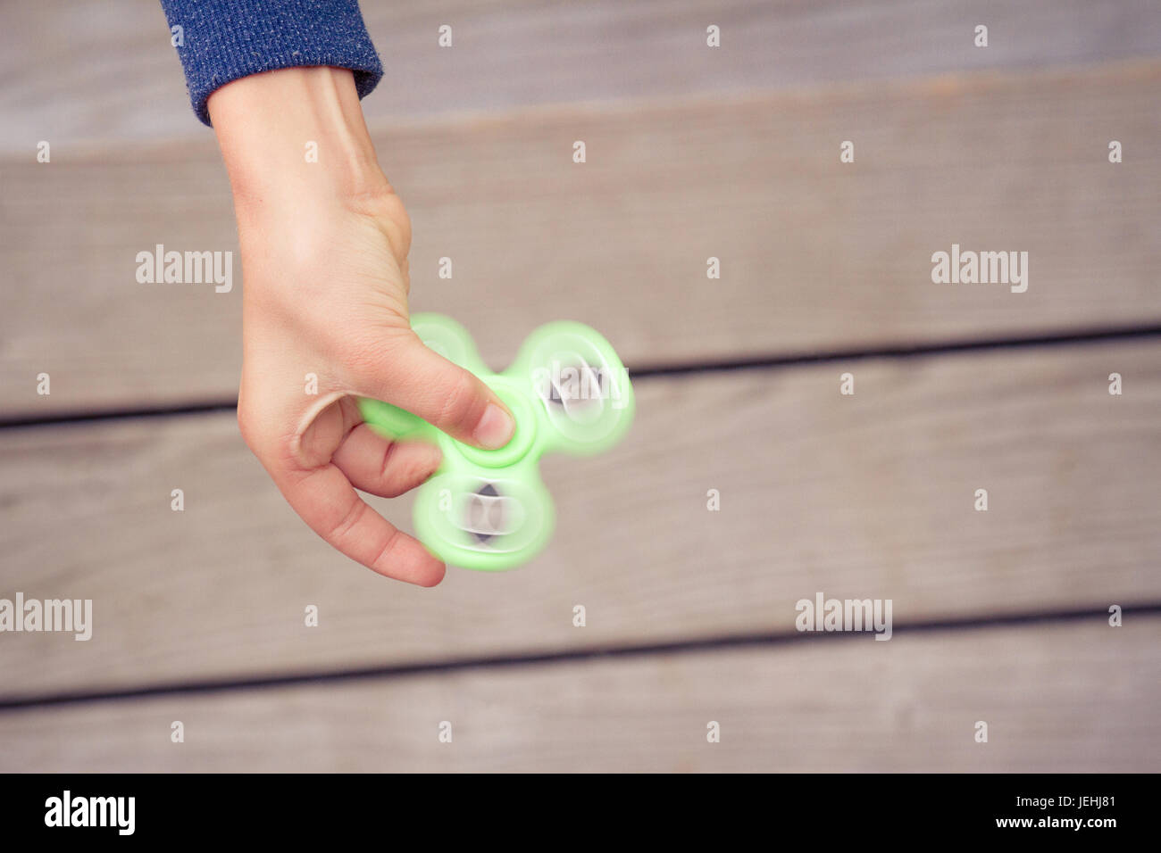 Kid holding popular fidget spinner toy. Top view Stock Photo - Alamy