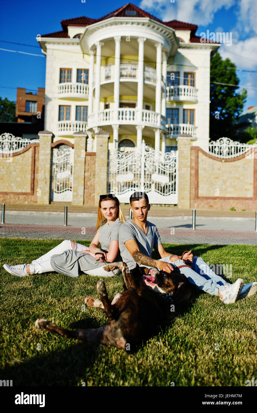 Couple in love with two dogs pit bull terrier on a walk Stock Photo - Alamy