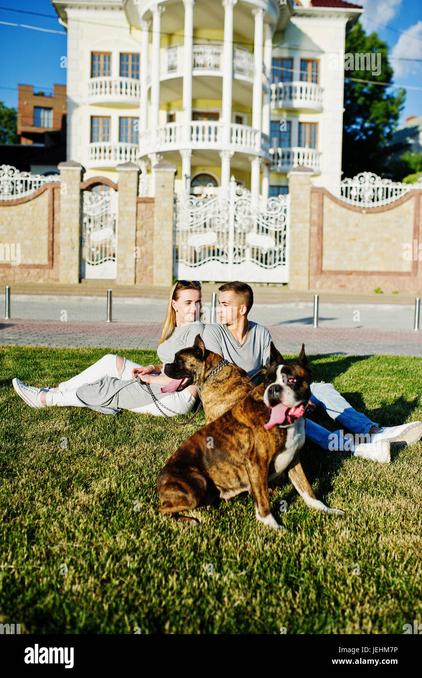 Couple in love with two dogs pit bull terrier on a walk Stock Photo - Alamy