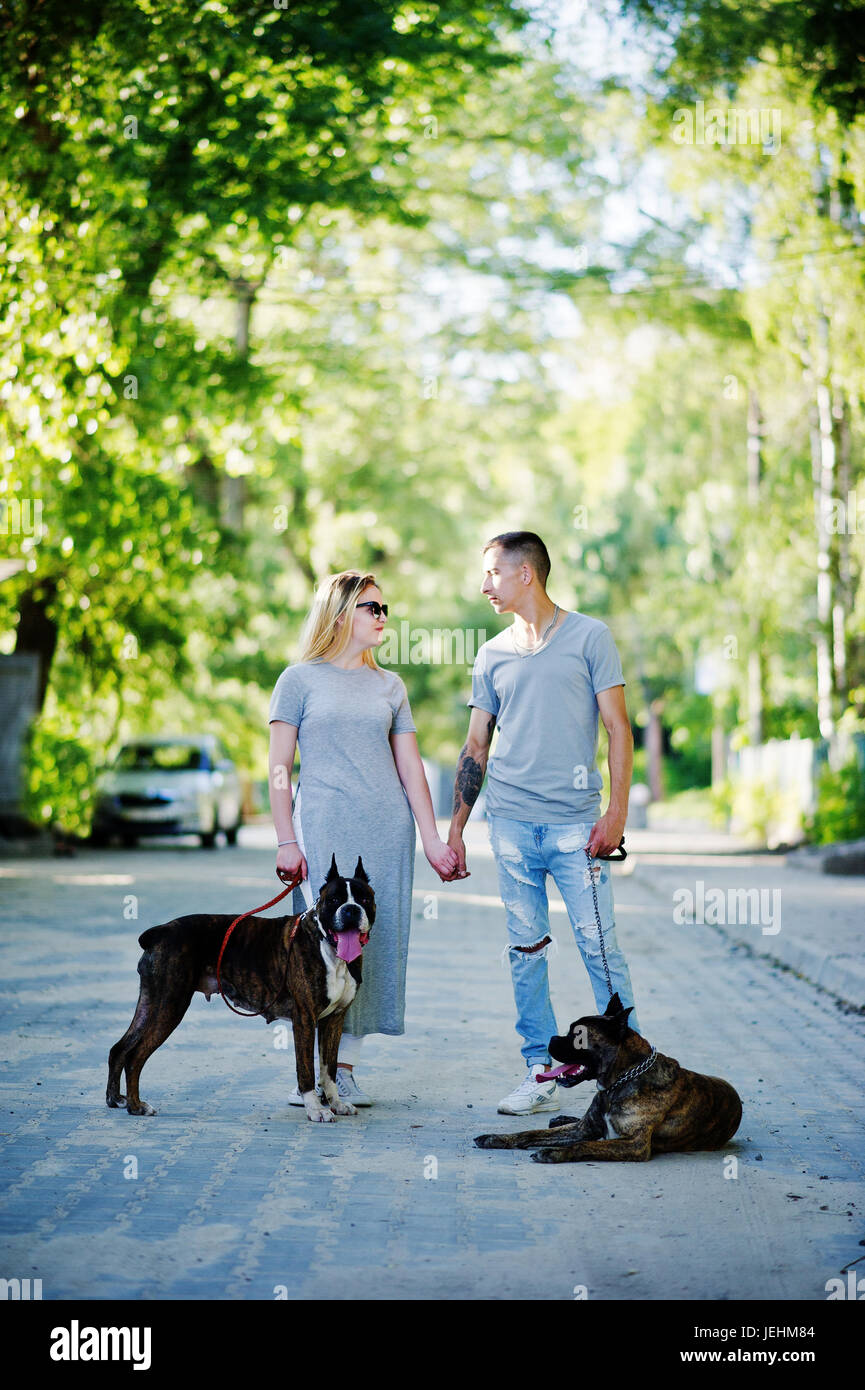 Couple in love with two dogs pit bull terrier on a walk Stock Photo - Alamy