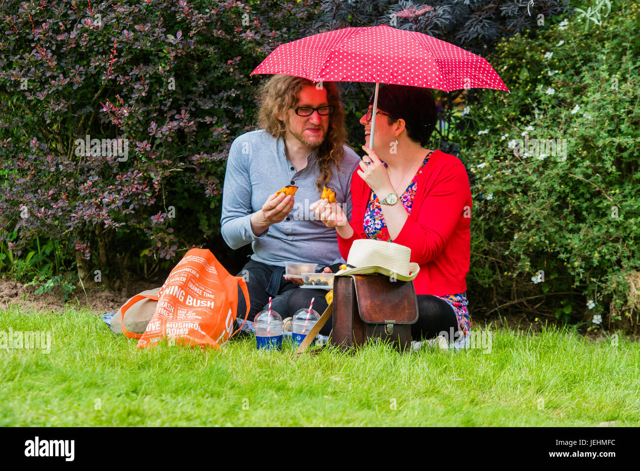 A couple picnicing in the rain under their umbrella at the 2017 Hay ...