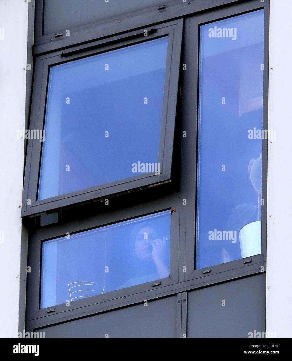 A woman looks out of a window in Bray Tower, part of the Chalcots ...