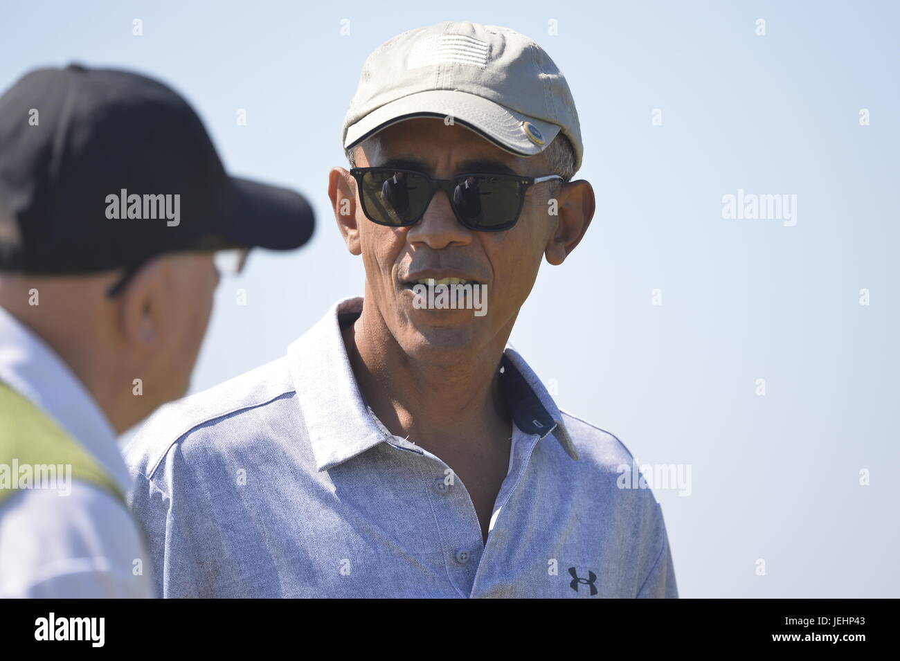 Former US president Barack Obama (light blue shirt) playing a round of ...