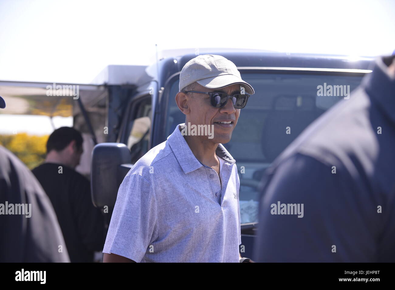 Former US president Barack Obama (light blue shirt) playing a round of ...