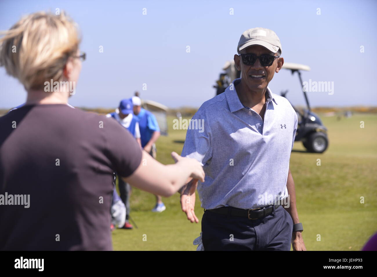 Former US president Barack Obama (light blue shirt) playing a round of ...