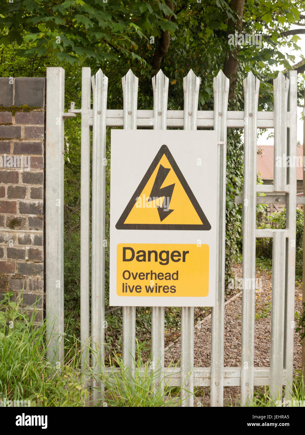 an electric safety sign outside on metal gate with electric bolt in ...