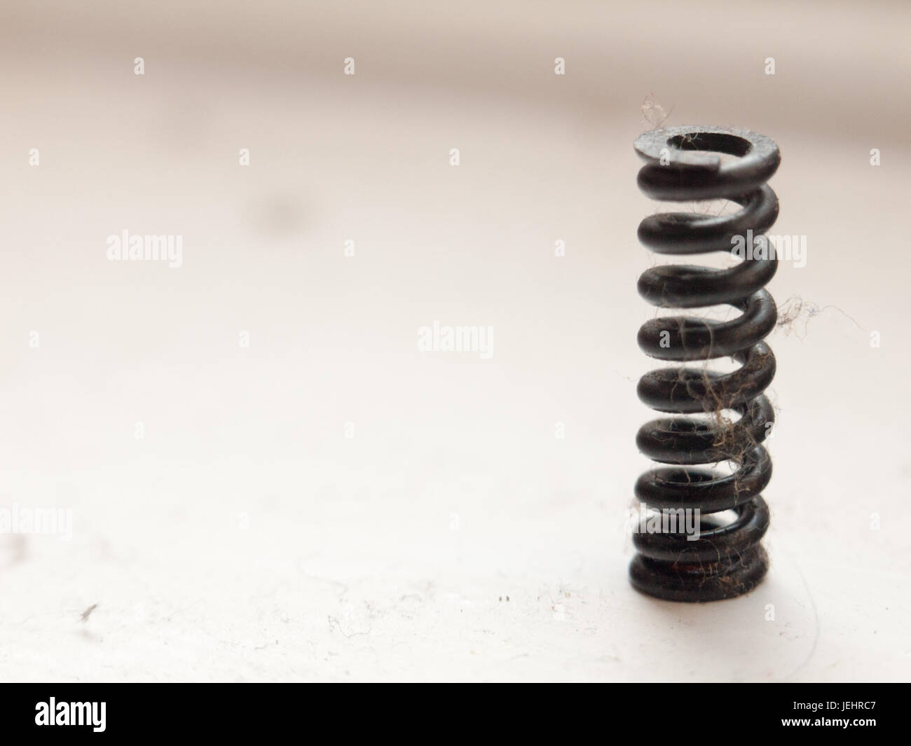 a small black coil spring on white Stock Photo - Alamy