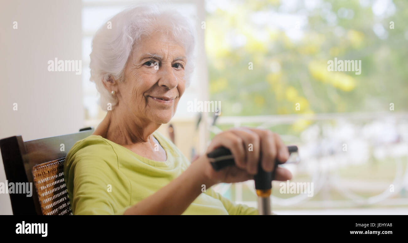 Portrait of old lady sitting on rocker at home. Happy elderly woman ...