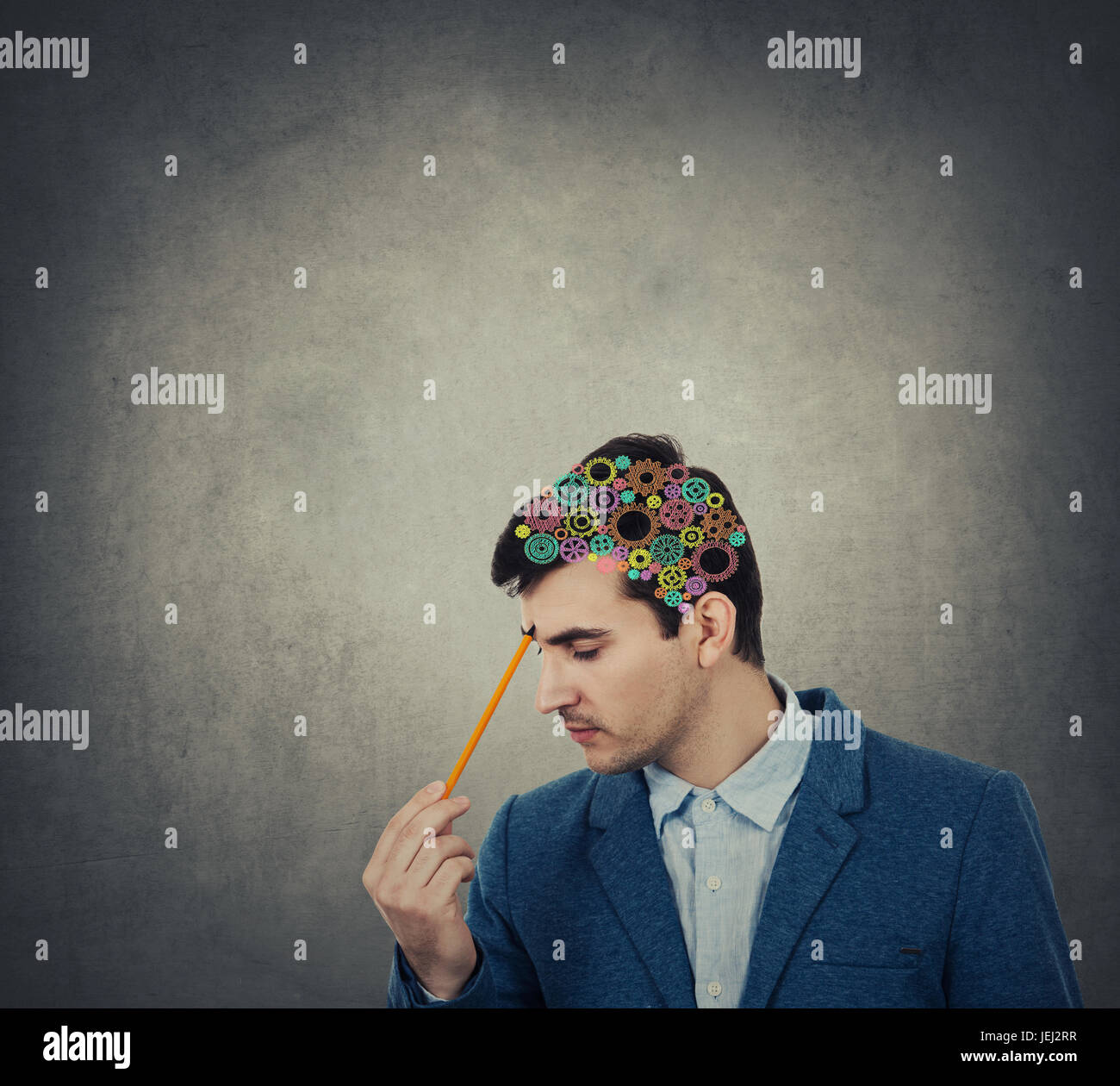 Creativity concept of a businessman pointing with a pencil to his head ...