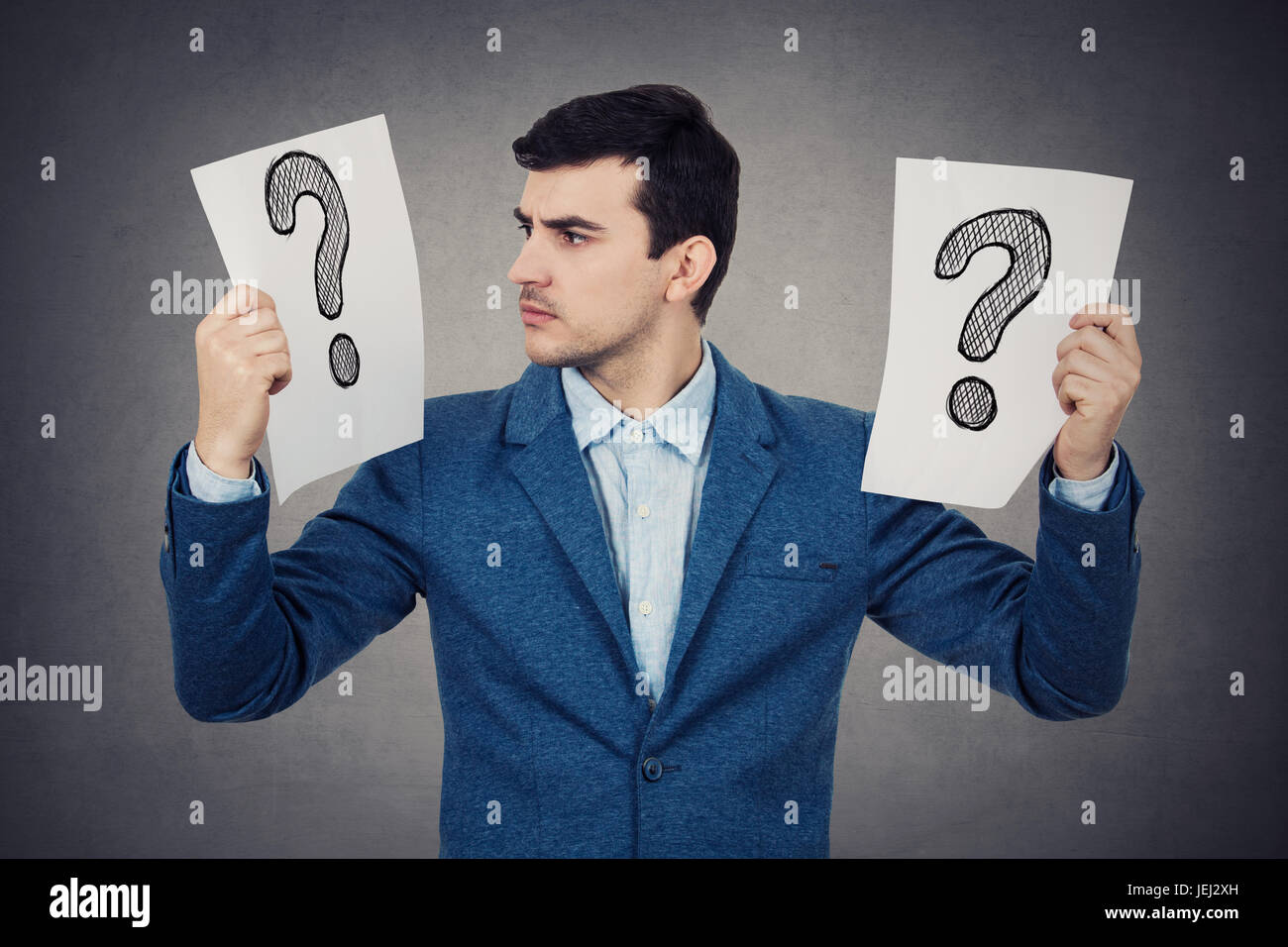 Perplexed young student businessman holding to white papers with ...