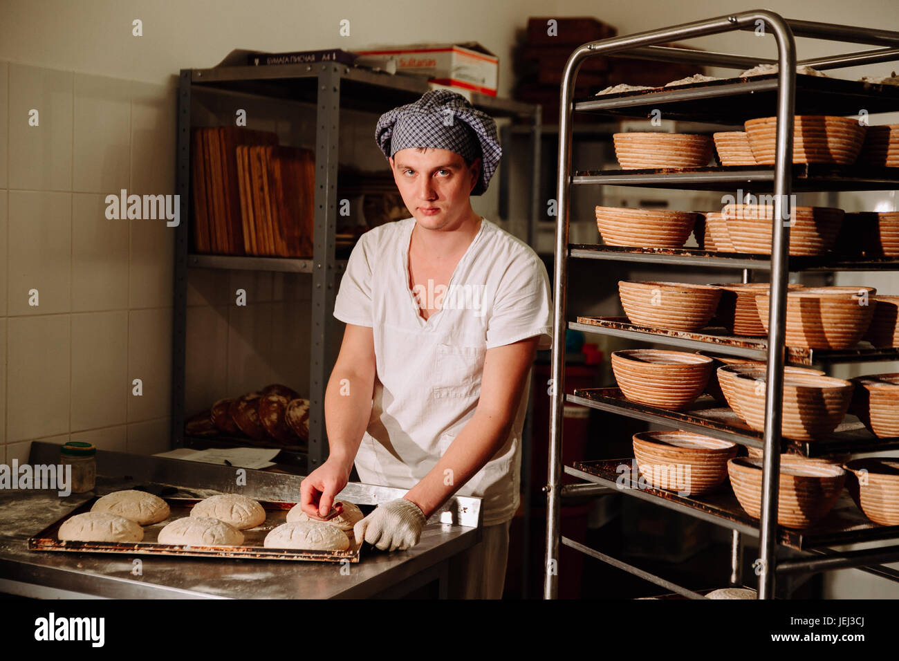Baker kneading dough and forming loaf of bread Stock Photo - Alamy