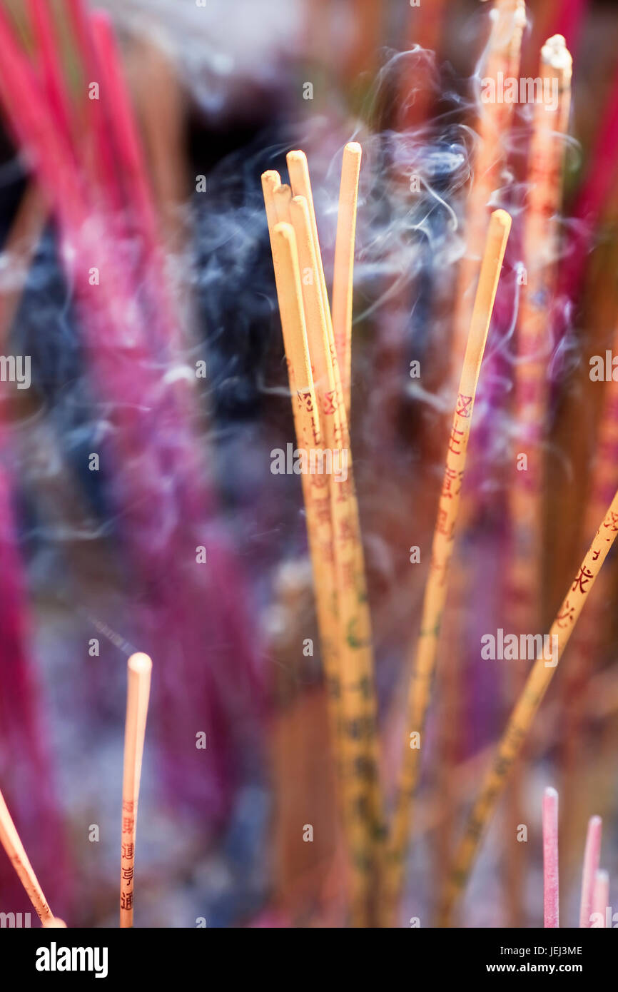 Purple and yellow incense sticks burning at an altar of a Taoist temple ...