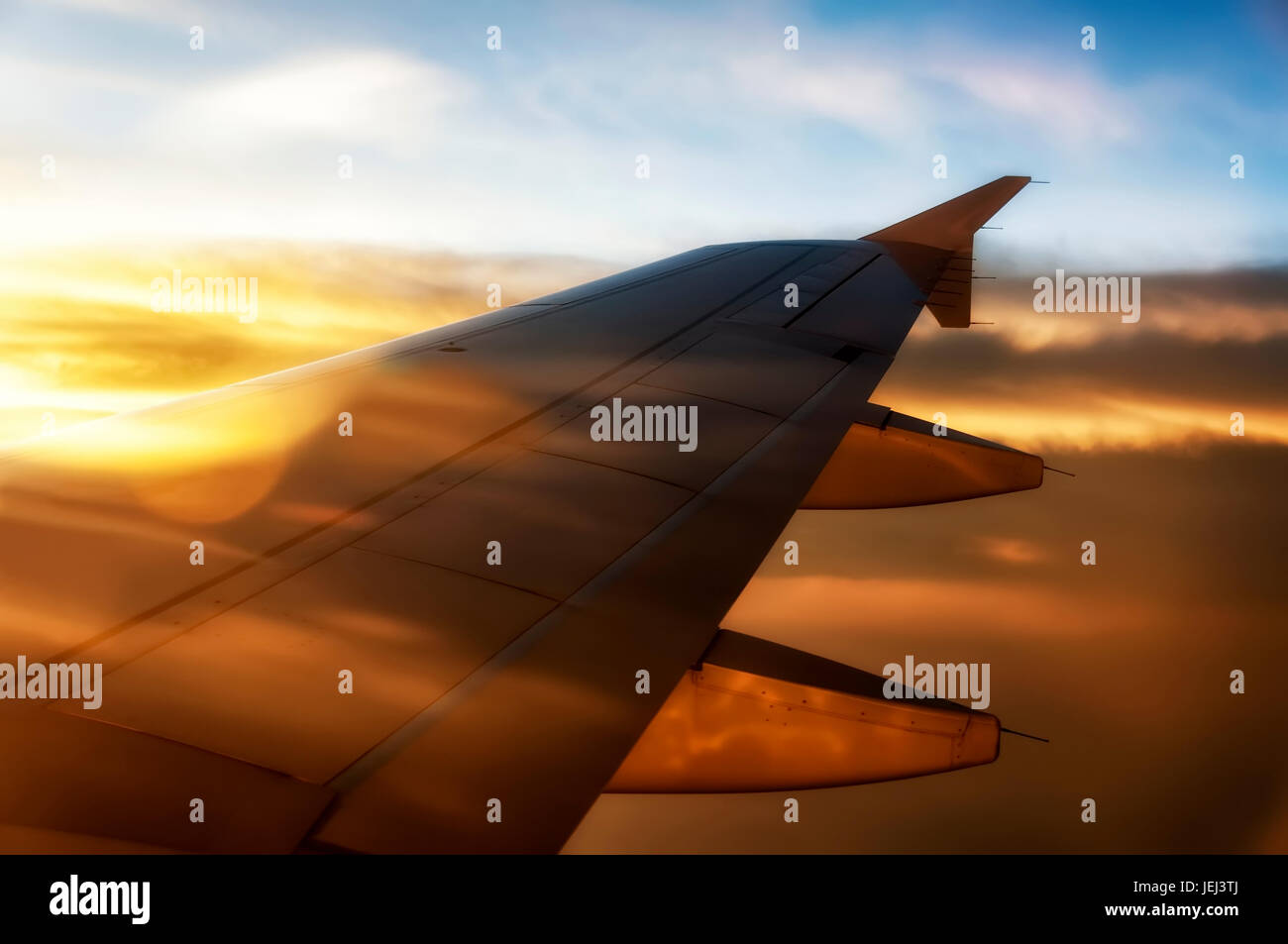 Wing of flying airplane during sunset Stock Photo - Alamy