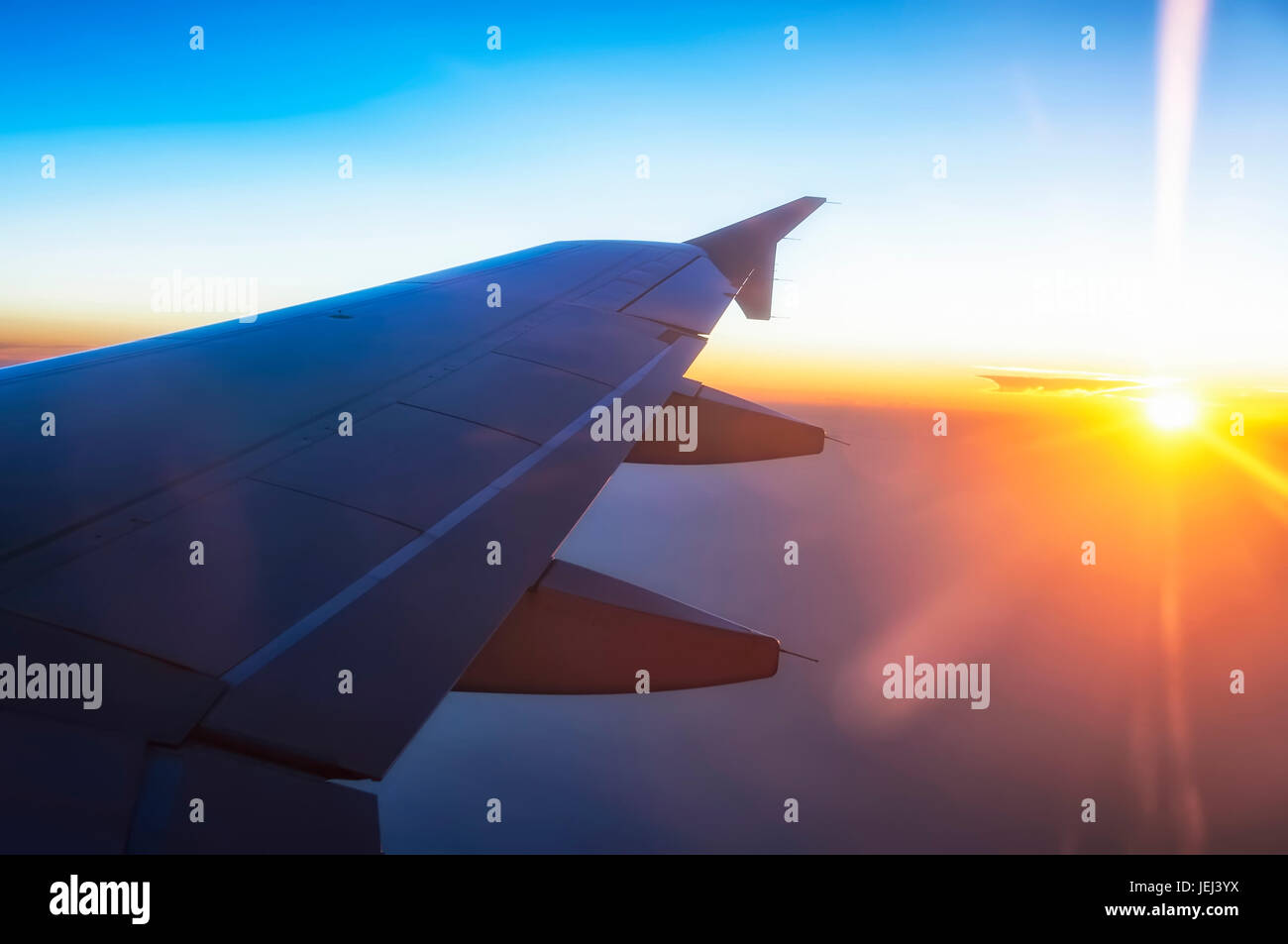 Wing of flying airplane during sunset Stock Photo - Alamy