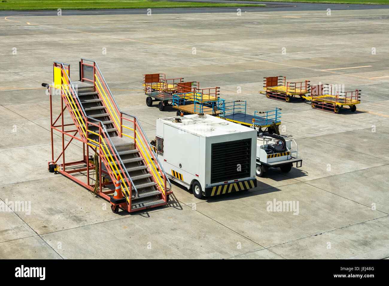 Airport service vehicles standby on airport tarmac with airplane Stock ...