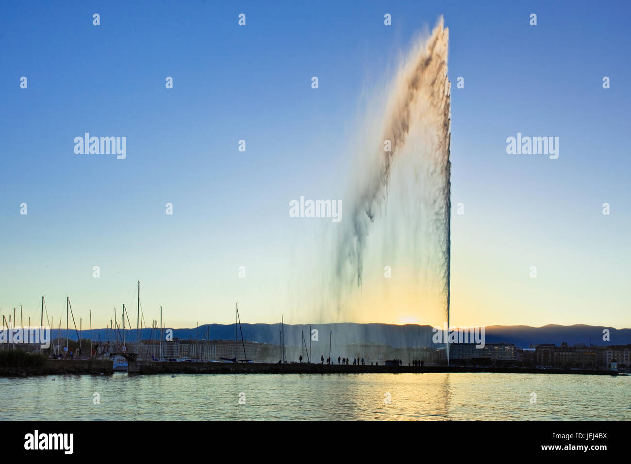The famous fountain “Jet d'Eau” in Lake Geneva at sunset Stock Photo ...