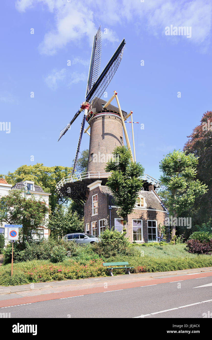 Ancient wind mill with mansion and lush foliage, Gouda, The Netherlands ...