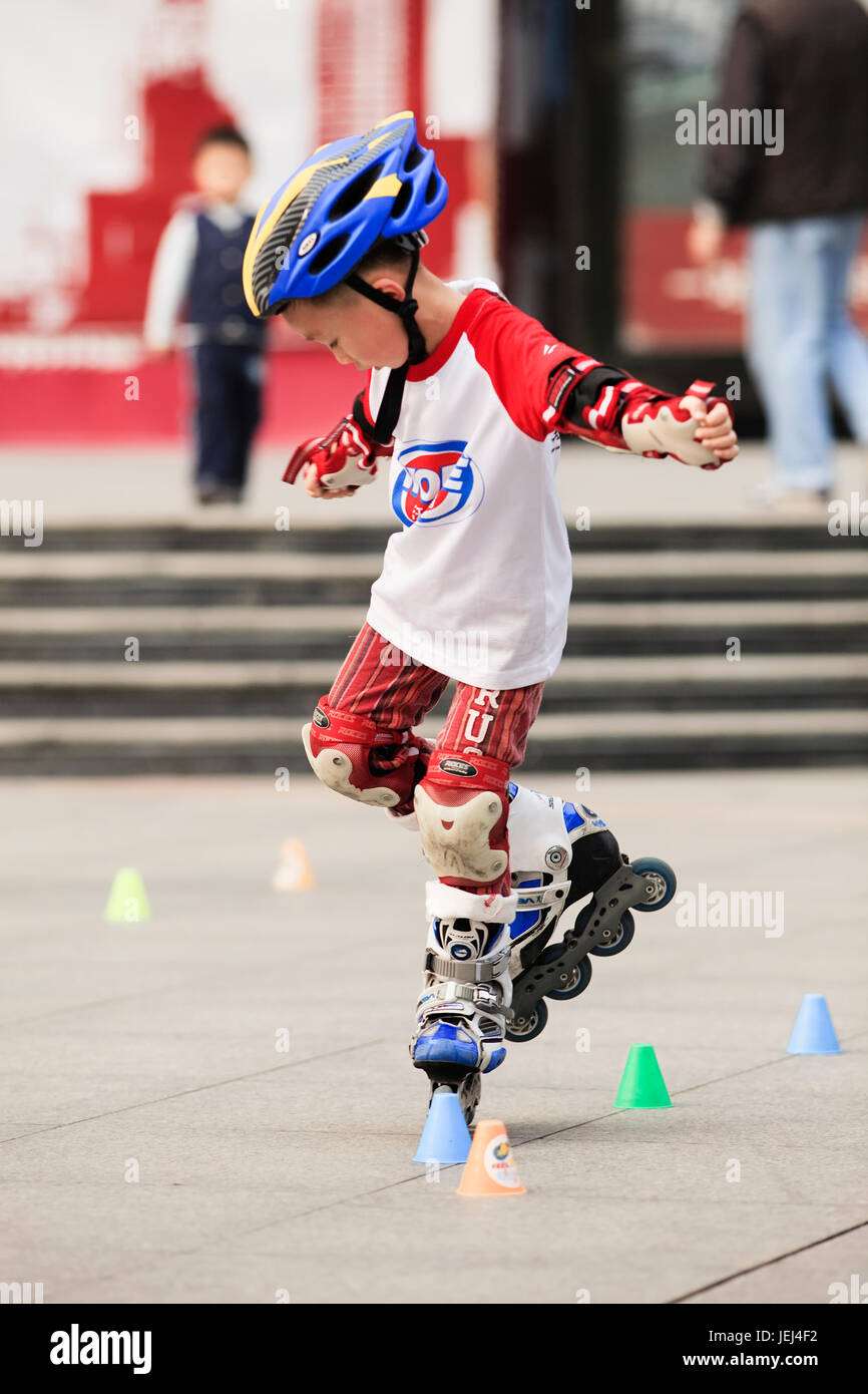 GUANGZHOU - DEC. 13, 2009. Boy in a colorful outfit on roller skates ...