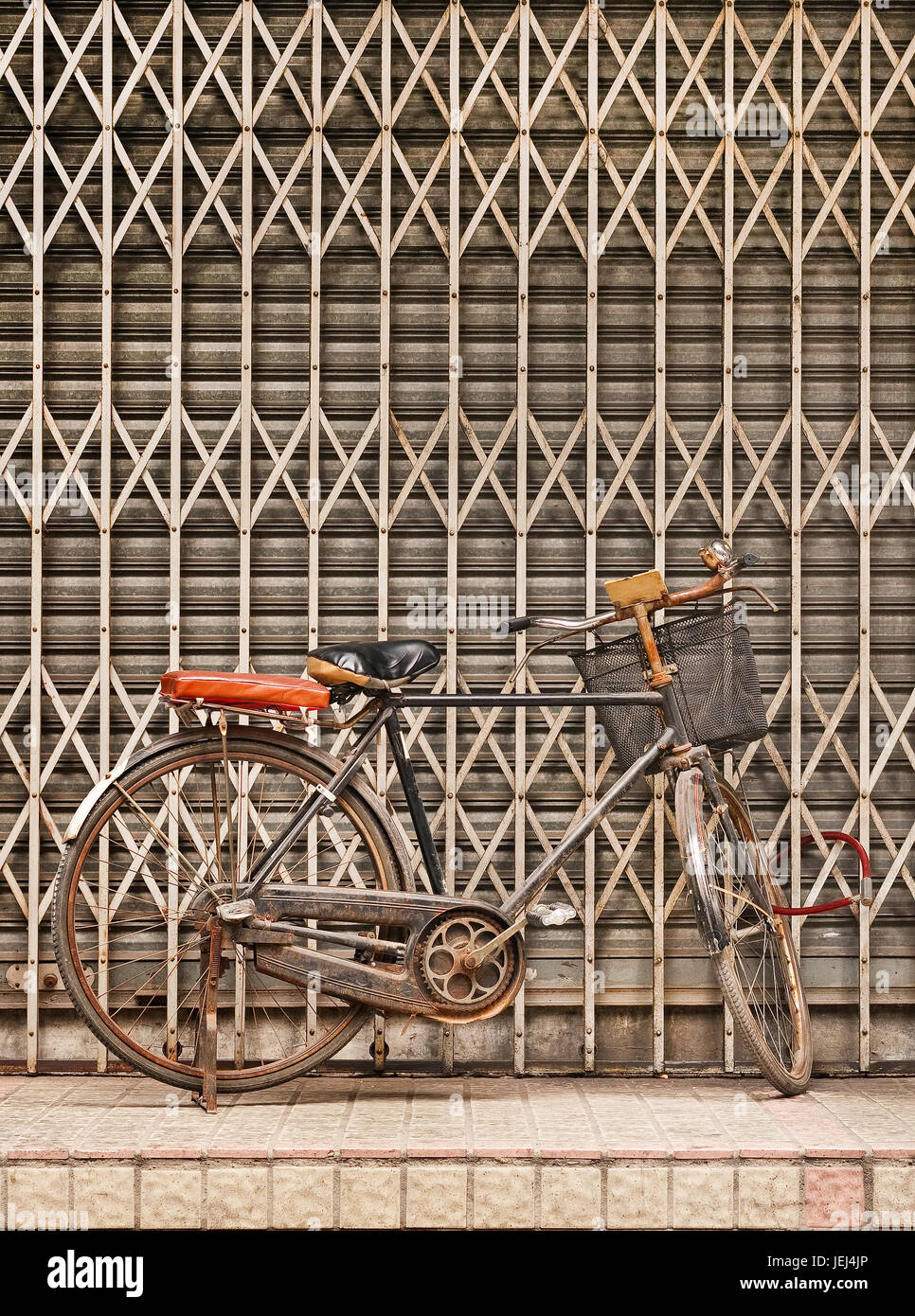 Rusty Chinese bicycle against roller shutter with fence Stock Photo - Alamy