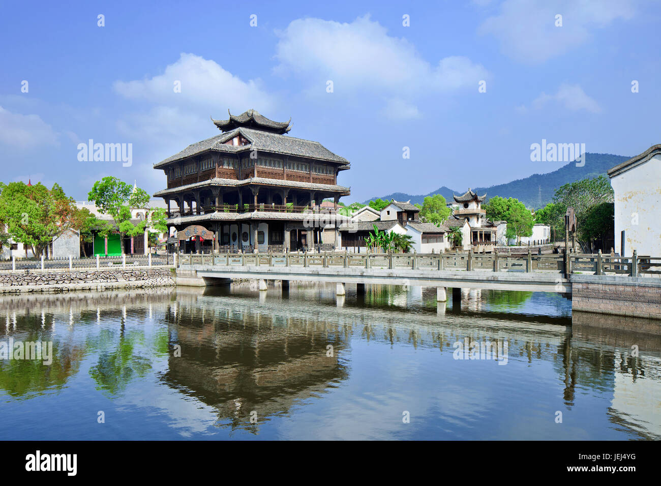 Ancient wooden house and bridge reflected in a tranquil canal, Hengdian ...