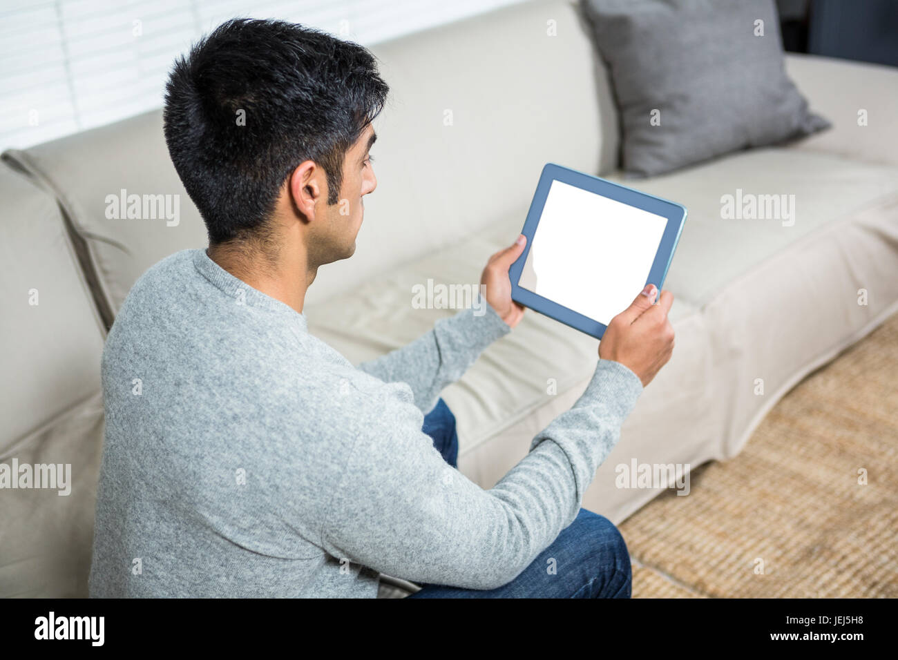 Handsome man using tablet on the sofa Stock Photo - Alamy