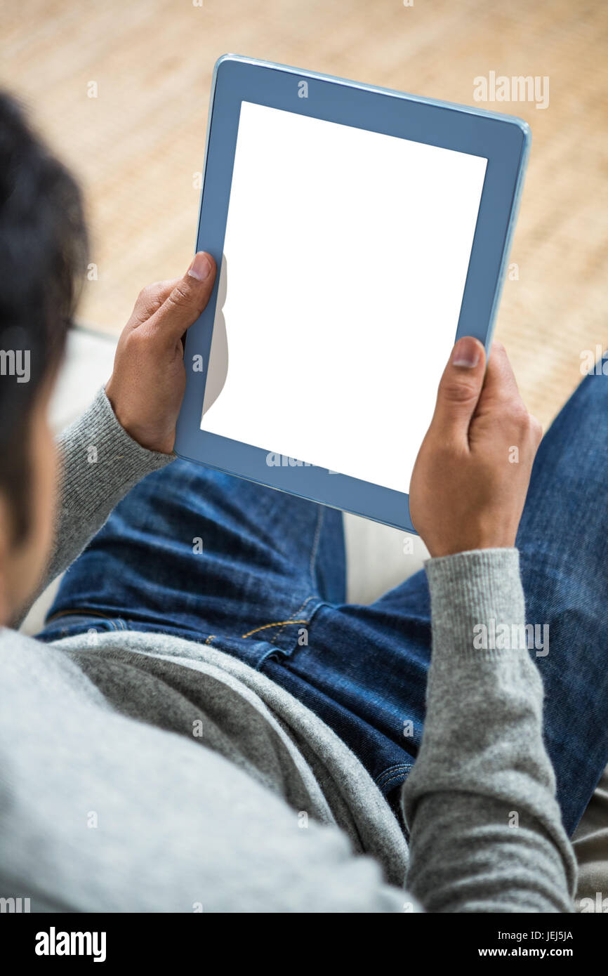 Handsome man using tablet on the sofa Stock Photo - Alamy