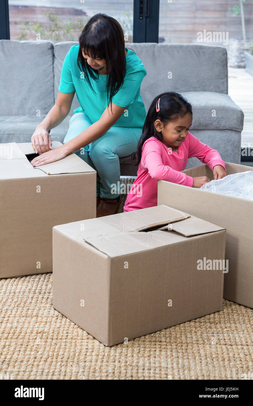 Happy mother and daughter opening boxes Stock Photo - Alamy