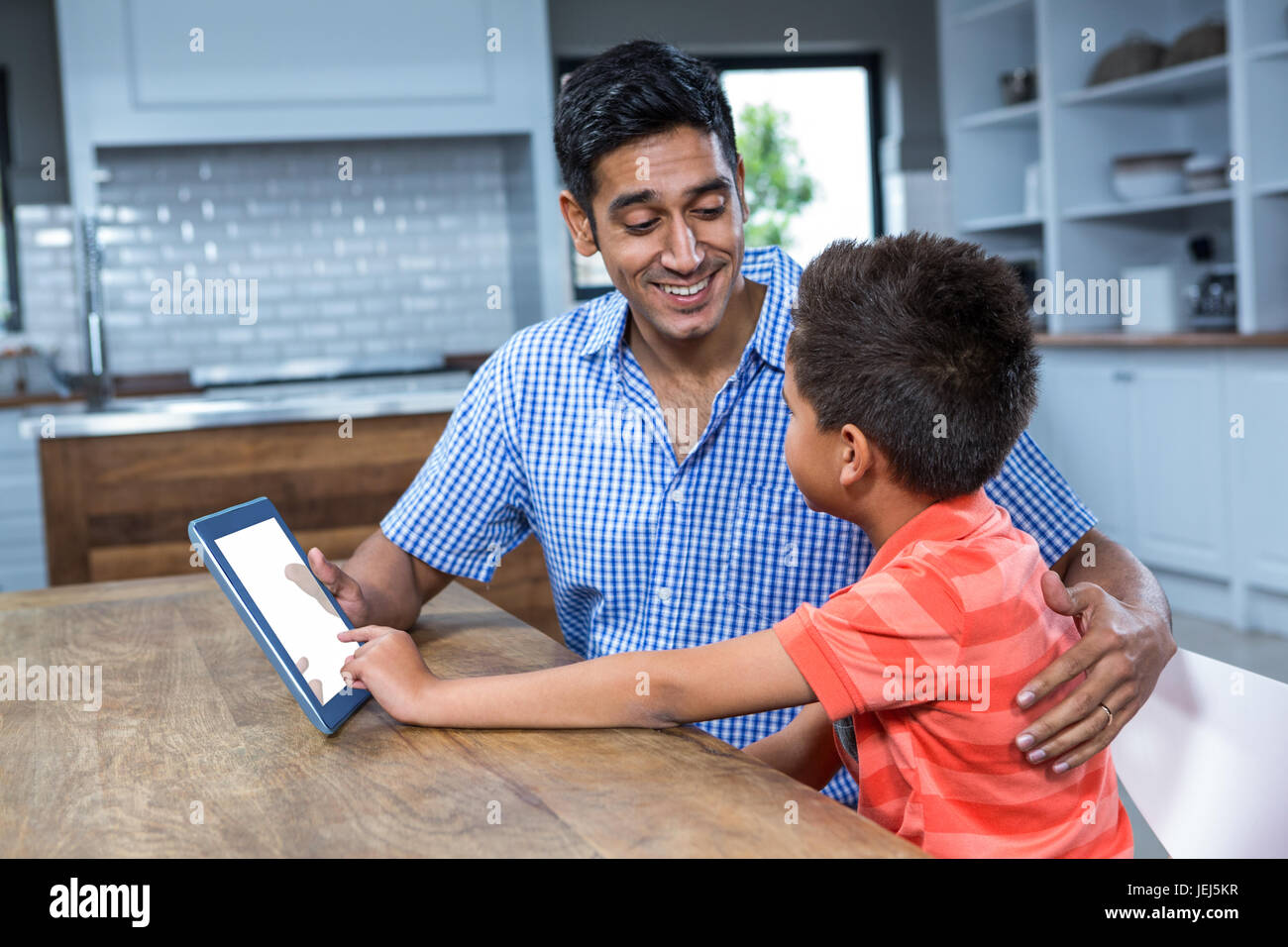 Smiling father using tablet with his son Stock Photo - Alamy