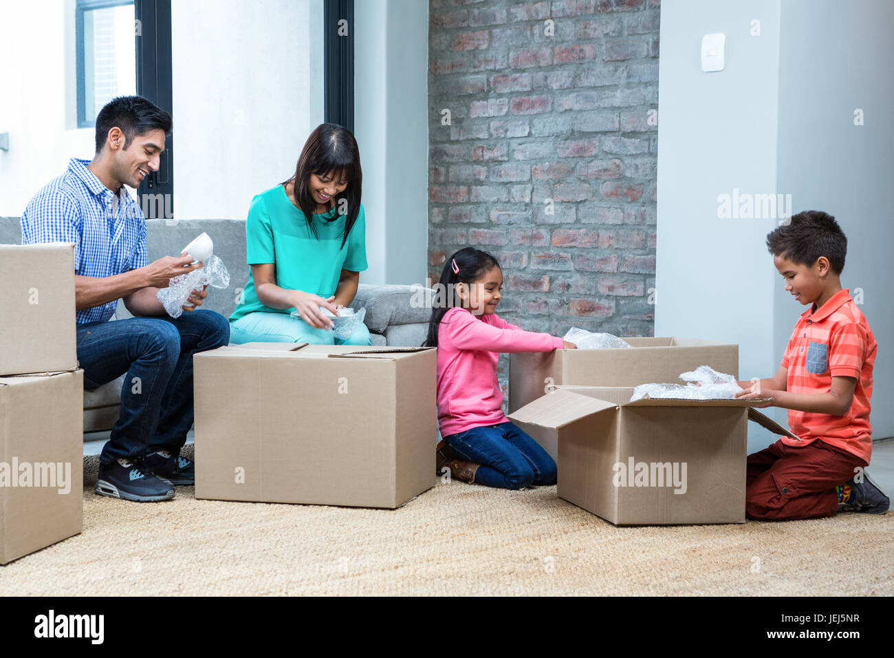 Happy family opening boxes Stock Photo - Alamy